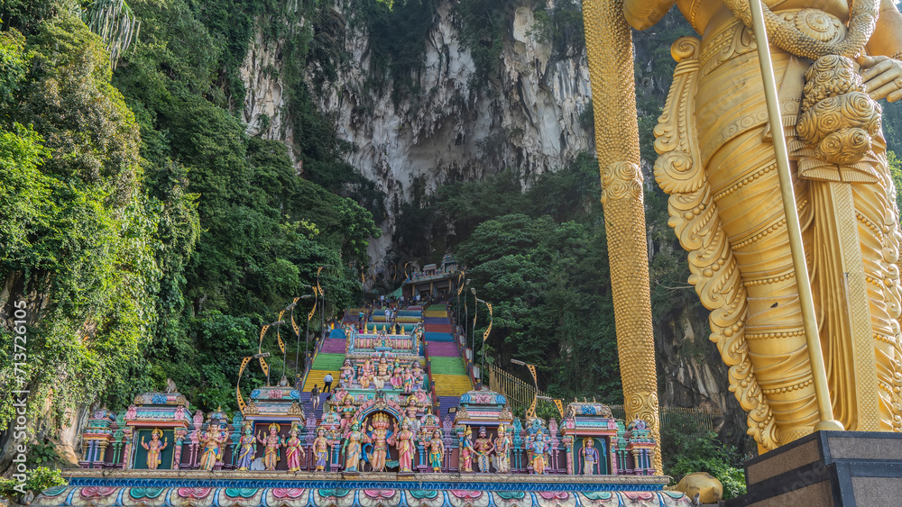 The Batu caves. Tiny silhouettes of people can be seen climbing the ...