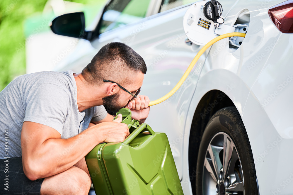 Weird man pumping gasoline from a gas tank into canister. Self ...