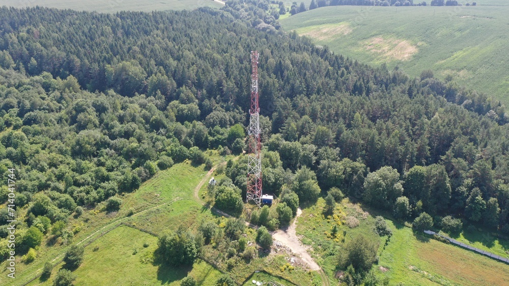 Cell tower in rural area surrounded by forest. Satellite communication ...