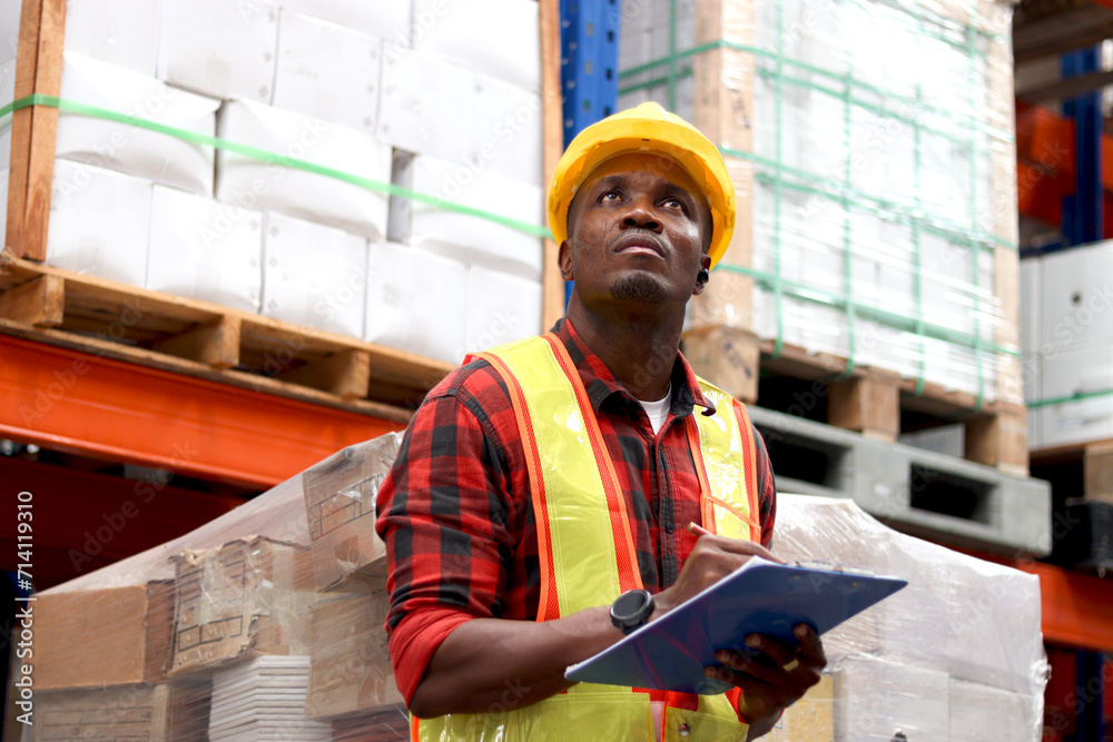 African worker wearing safety vest and helmet, holding file folder ...