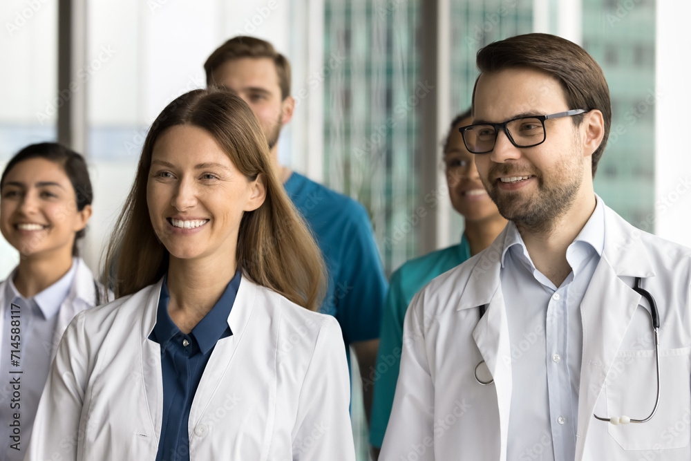 Cheerful young practitioners standing together for shooting, looking ...