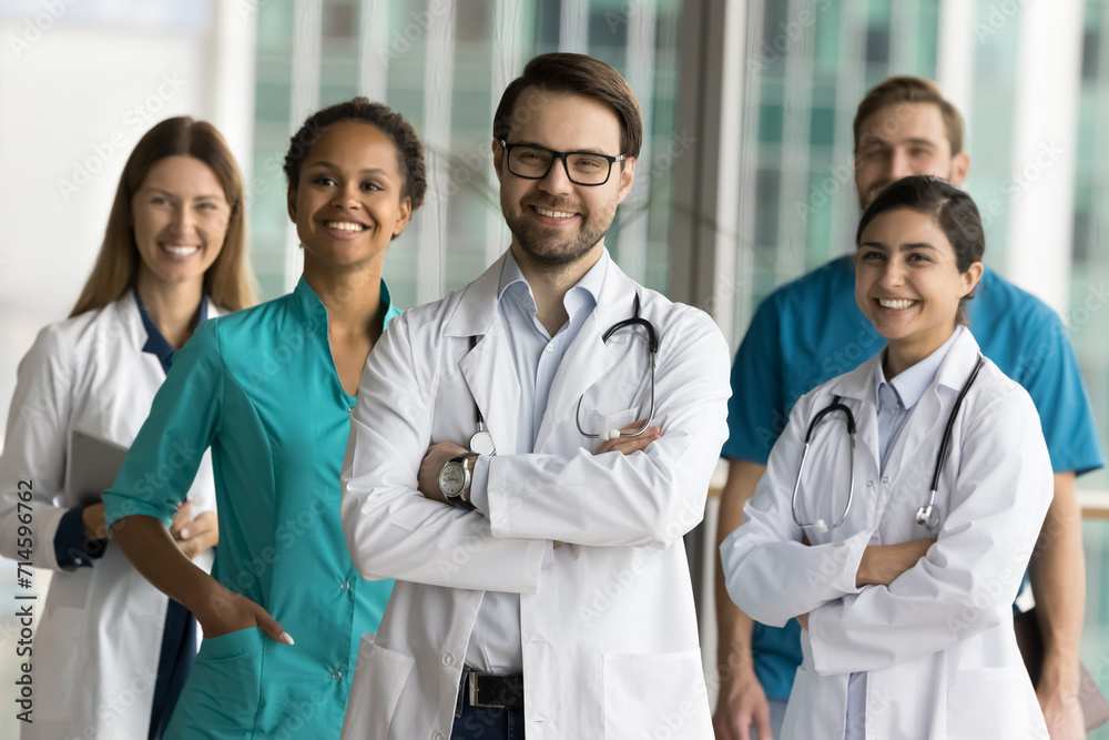 Happy positive chief doctor man with stethoscope posing for group ...