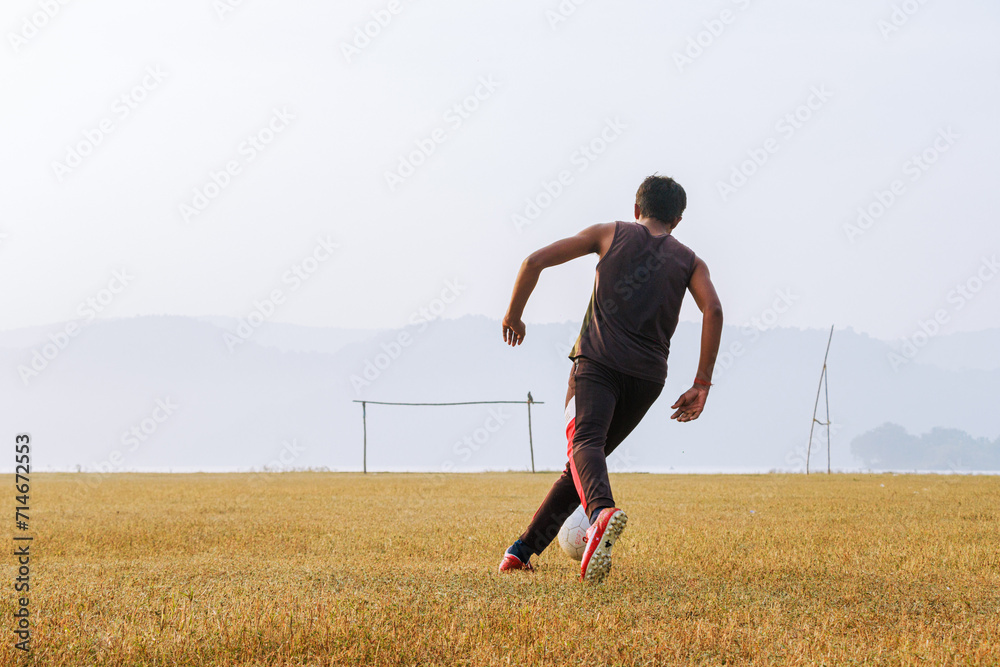 Running Soccer Football Player. Young Indian Footballer Kicking ...