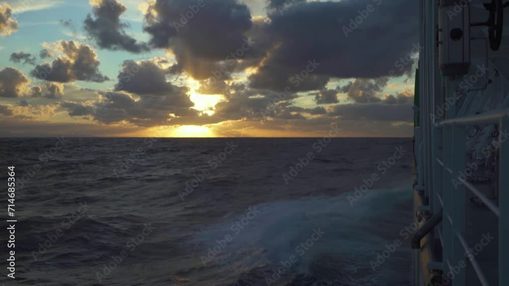 Storm and sun at sea. Rays of sun through clouds. Splashes from bow of ...