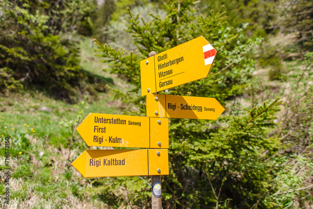 Yellow hiking trail signs in Switzerland at Mt. Rigi in the Swiss Alps ...