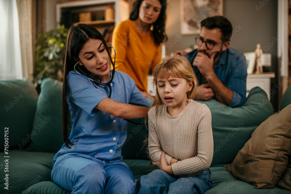 Mom and dad observe attentively as a home nurse ensures their kid's ...