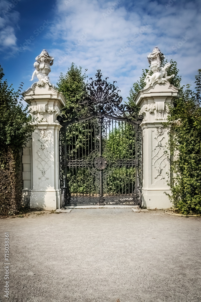Black metallic ornate gates and white columns in Ancient white baroque ...