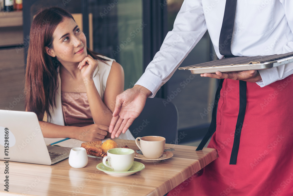 Restaurant business Handsome waiter serving food to young beautiful ...