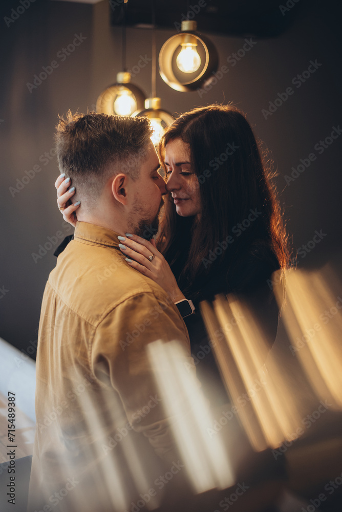A girl and a guy are standing opposite each other. The man gently holds ...