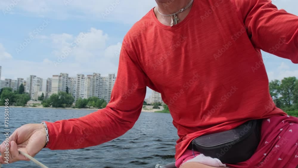 Skillful yachtsman lowers anchor slowly to bottom using rope ...