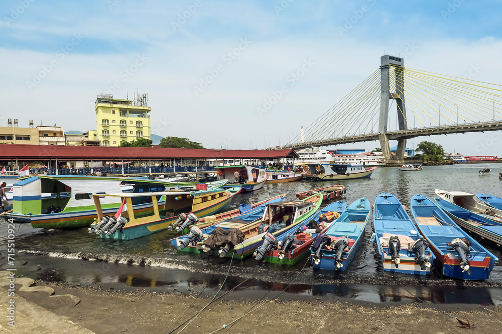 Typical ferry boats in Manado port with the Soekarno Bridge beyond in ...