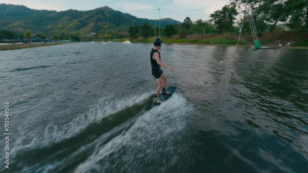 Profi wakeboarder man riding board jibbing slide ramp extreme trick ...