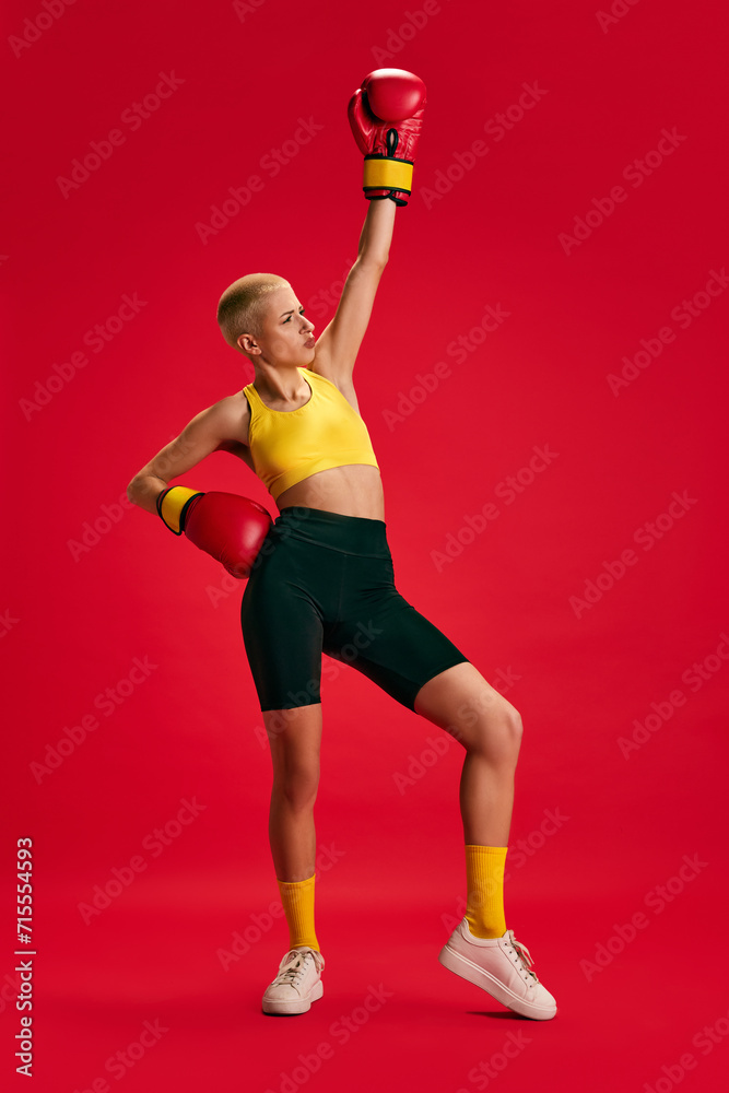 Full-length portrait of young emotional woman posing raising hand in ...
