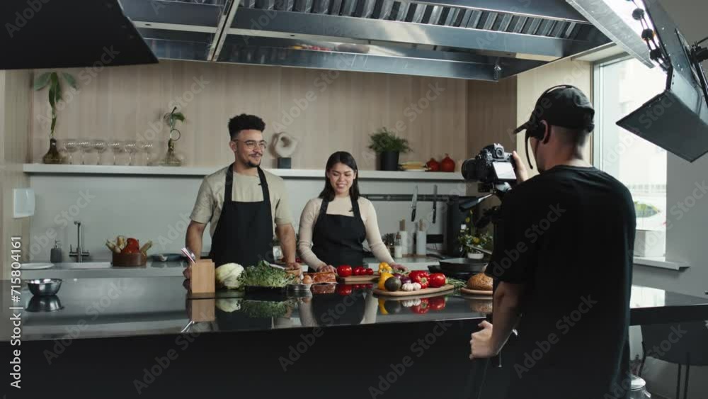 Vidéo Stock Cameraman filming cooking TV show hosted by young male and ...