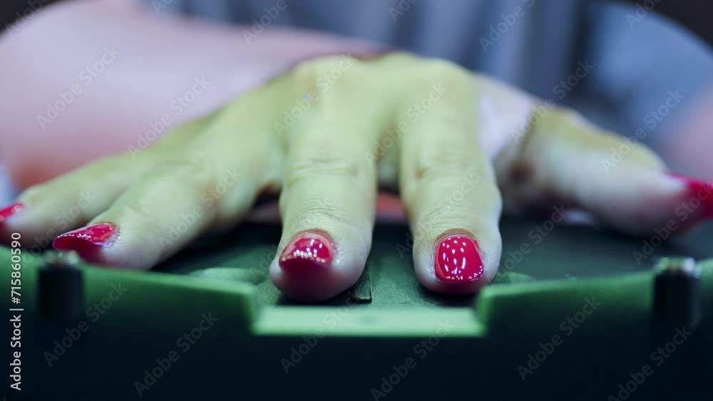 Close-up video of a woman's hand in the ultraviolet light drying booth ...