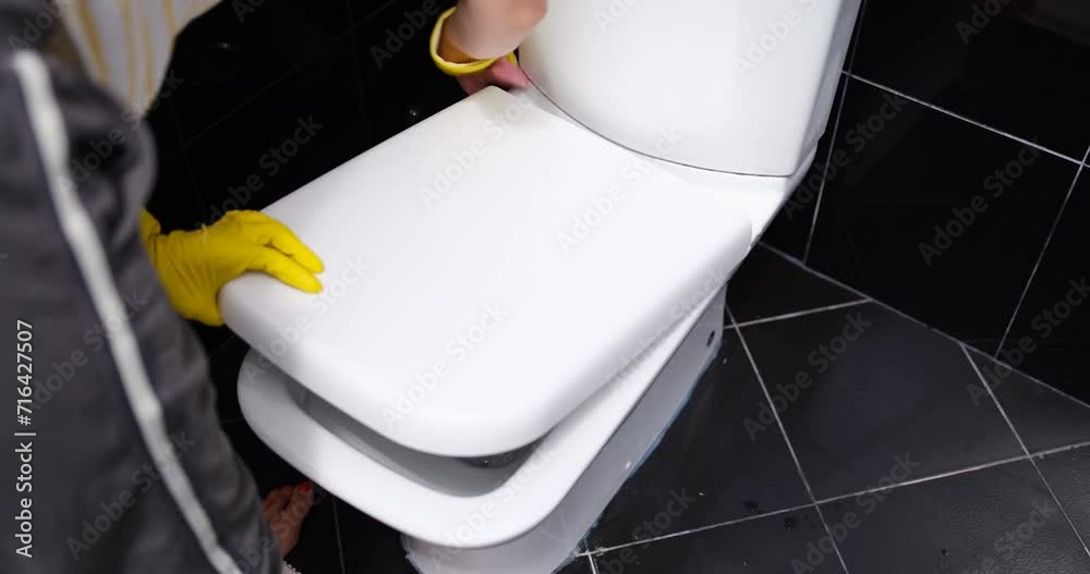 Woman cleans house washes toilet bowl and closes toilet lid. Toilet ...