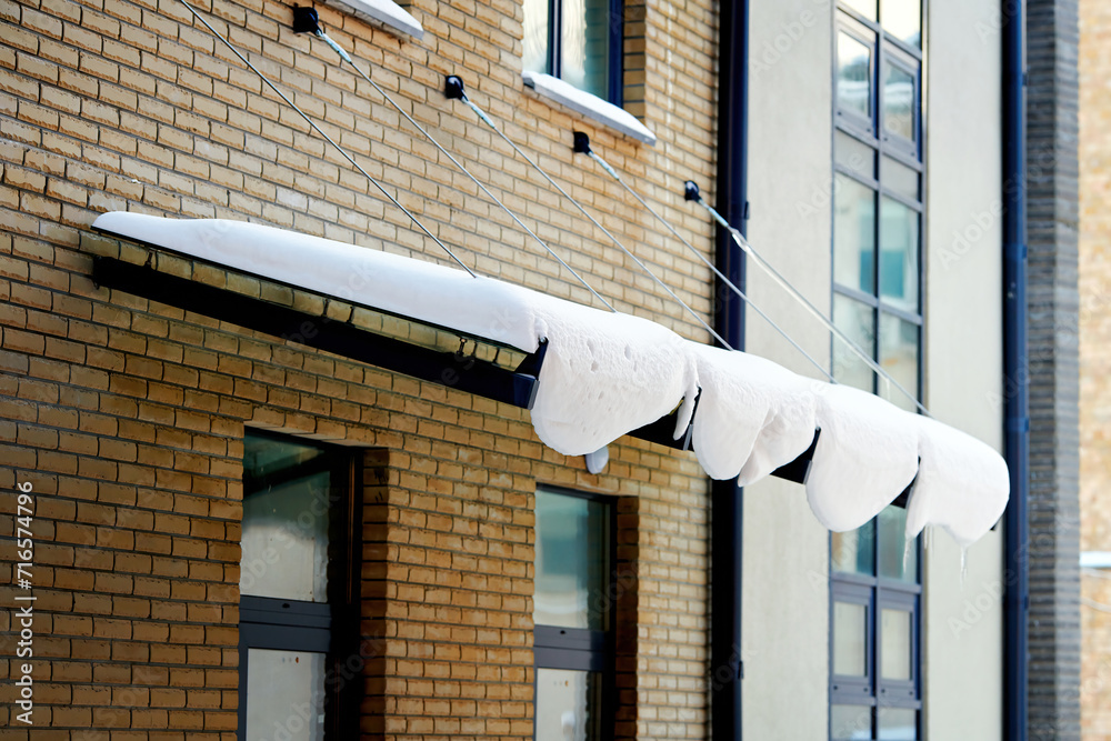 Door canopy with snow and ice, danger for pedestrians. Glass panel ...