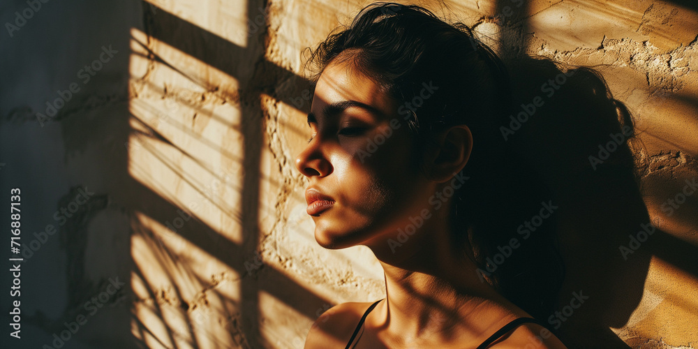 Contemplative woman in profile, her face etched with shadows and light ...