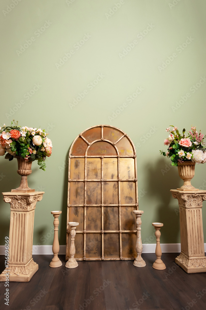 an iron frame with a gold mirror and flower pots on a pedestal. a photo ...