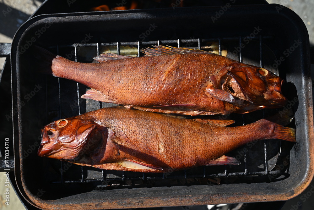 Smoked fish in smokehouse box. Hot smoked river bass fish cooked with ...