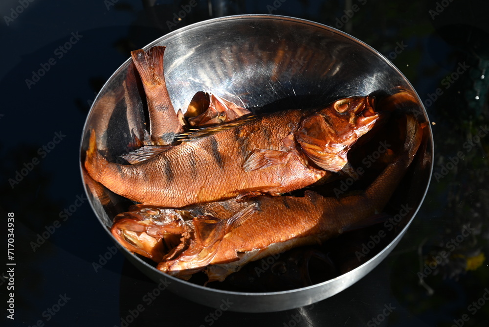 Smoked fish in smokehouse box. Hot smoked river bass fish cooked with ...