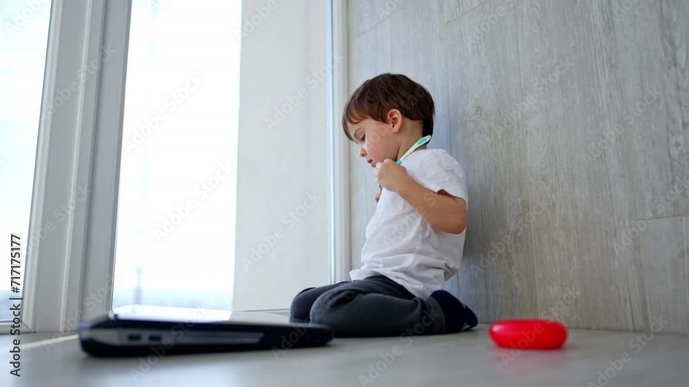 Vidéo Stock Adorable Caucasian child sits at the panoramic window. Kid ...