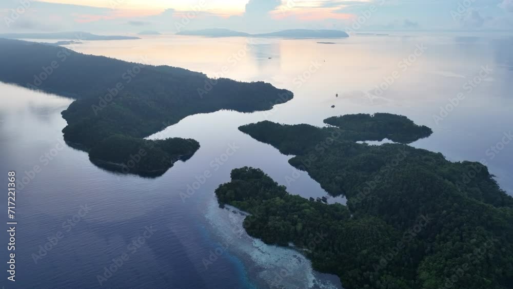 Sunrise illuminates calm seas around the islands of Gam and Yangeffo in ...