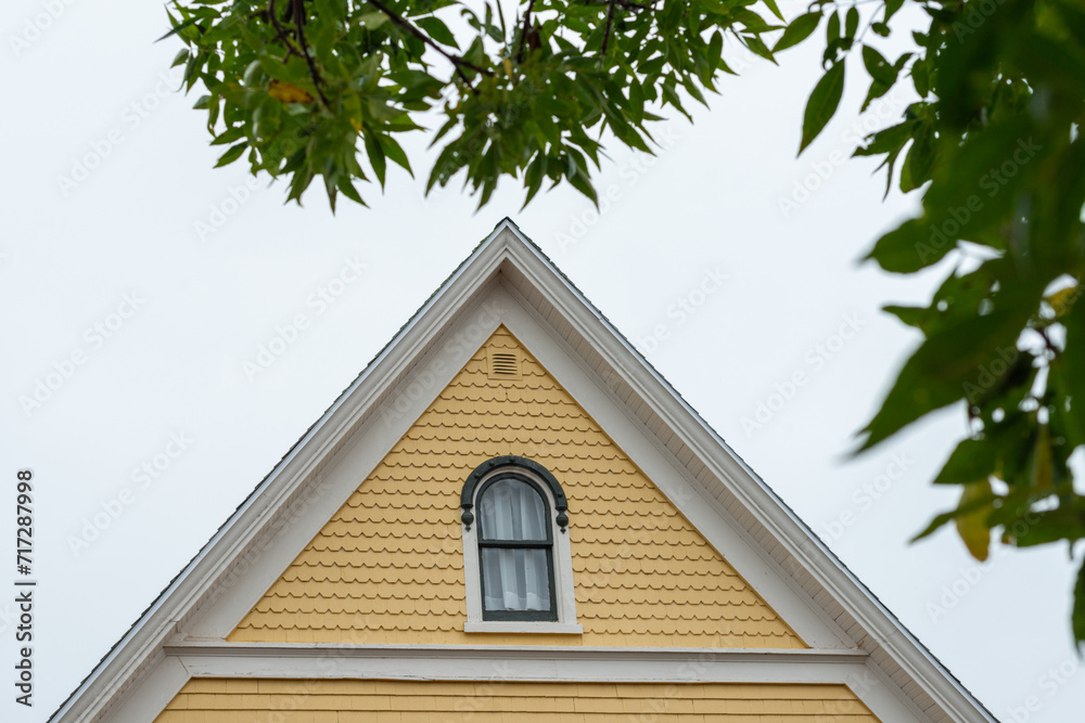 The exterior wall of a bright yellow country cottage with white trim ...