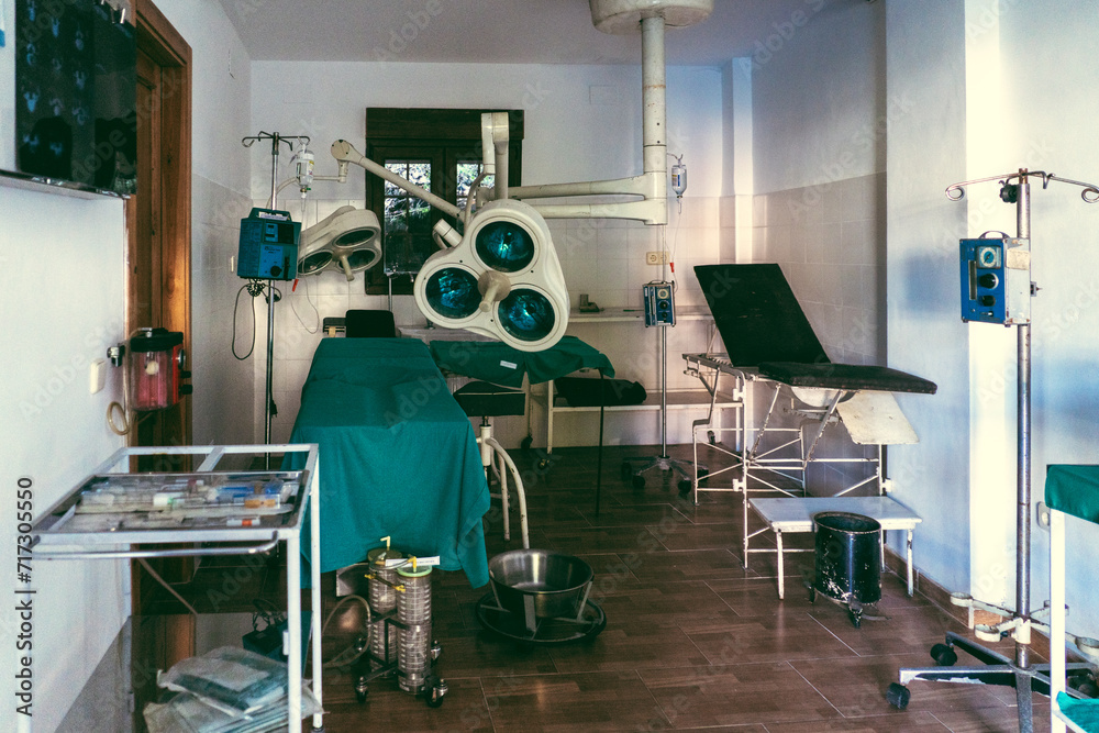 old medical operating room with ceiling lights, stretchers, beds, and ...