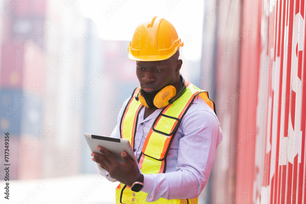 African American male container yard worker working and checking ...