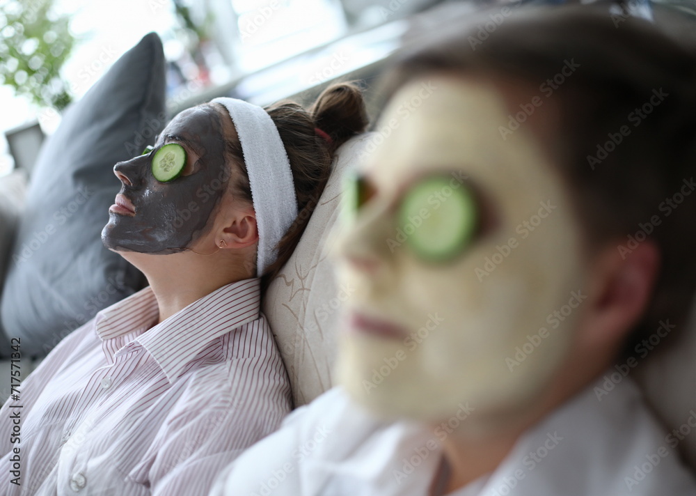 People are lying on couch with cosmetic mask faces. Man and woman lie ...