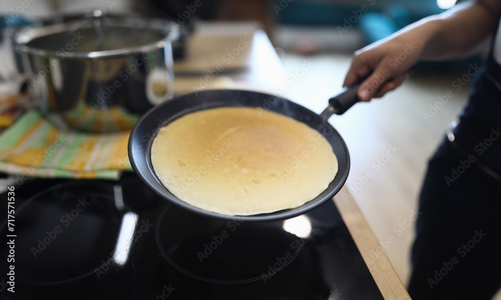 Hand holds pan with pancake, cooking at home. Available products, home ...
