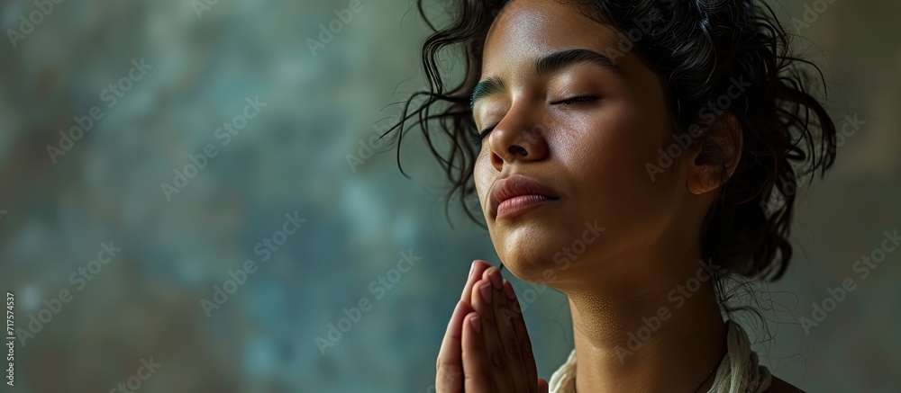 One young hispanic black woman in joining hands in prayer Meditative ...