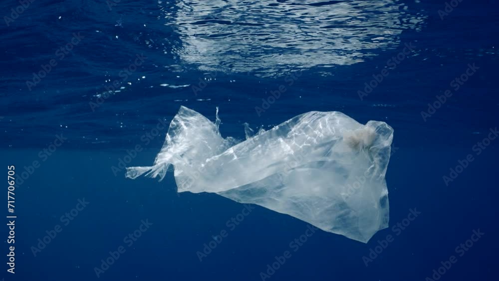 Vidéo Stock Disposable acrylic bag floating under waves reflected in ...