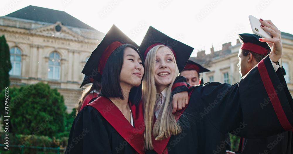 Mixed-races young beautiful girls, master students graduates smiling to ...