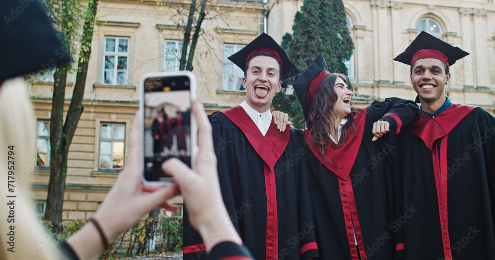 Back view of the blond graduated girl in academic cap taking photo on ...