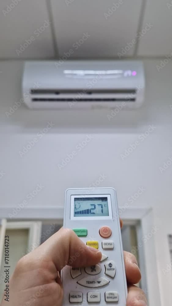 Closeup man hand holding a remote control to the air conditioning ...