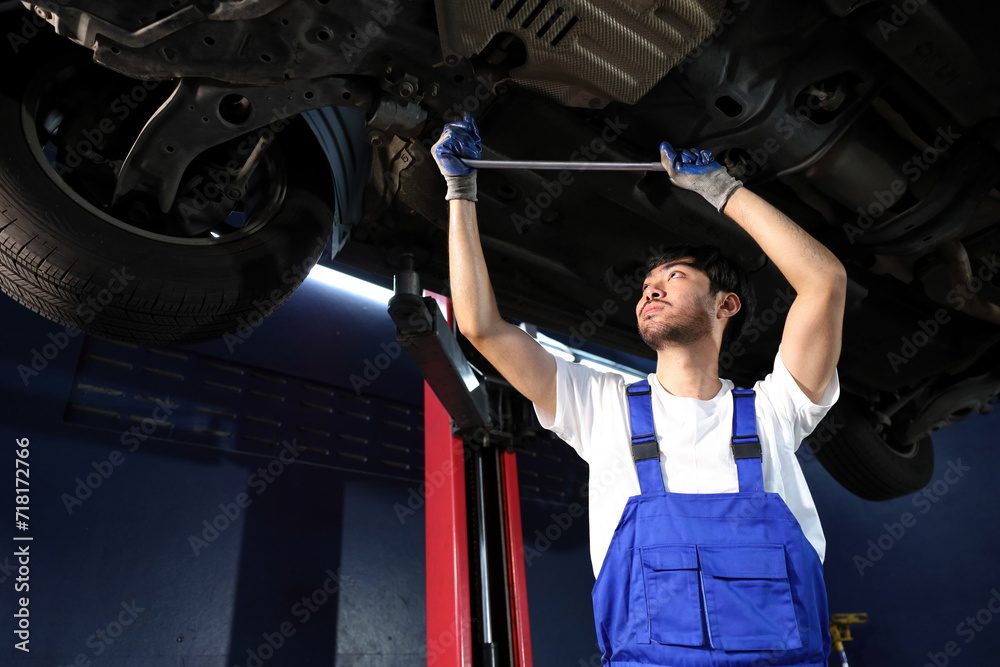 mechanic using ratchet wrench and fixing underneath the car Stock Photo ...