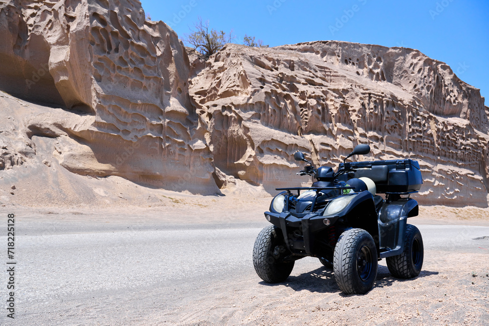 Quad bike parked on the seafront near the sandy beach of Monolithos on ...