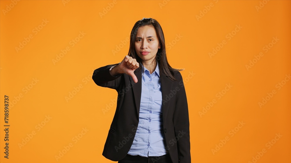 Photo & Art Print Asian female model giving dislike in front of camera ...