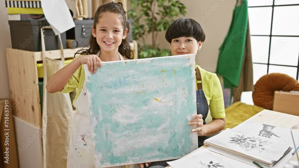 Confident art teacher and student showoff their canvas drawing, smiling ...
