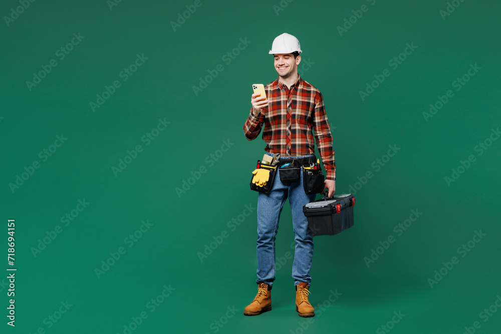 Full body young laborer man in red shirt hardhat hat work hold point on ...