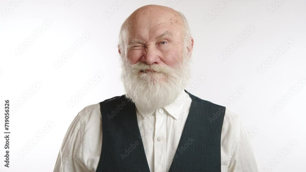 Senior man with a white beard caught in a moment of joy, playfully ...