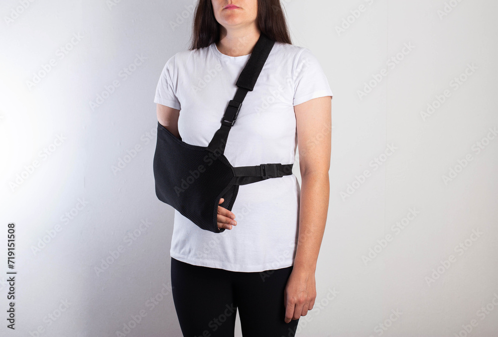 A girl in white with a black support bandage for her arm after a ...