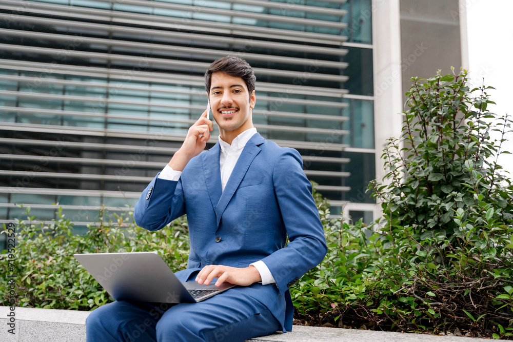 With a serene expression, a young Hispanic businessman engages in a ...