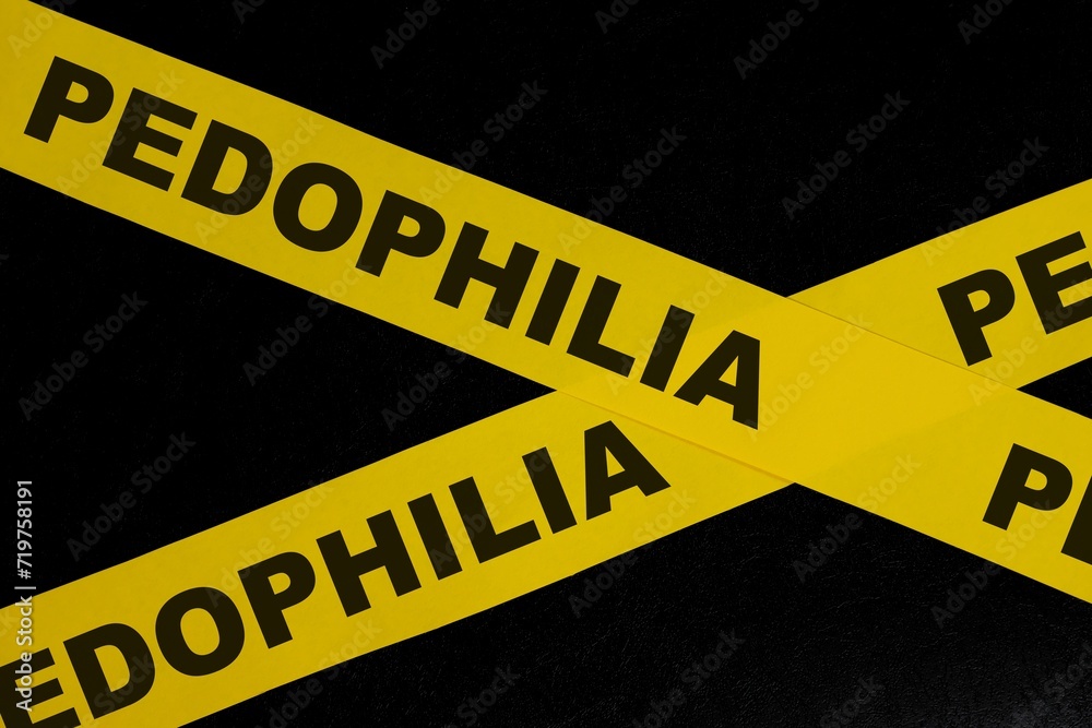 Pedophilia caution and warning concept. Yellow barricade tape with word ...