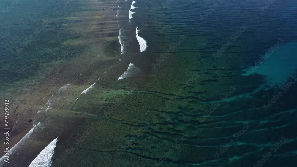 Spur and groove reef flats in clear ocean water as waves crest and ...
