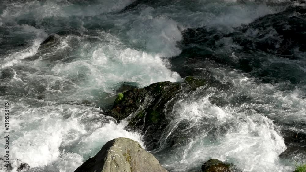 Water stream flows through the stones, in slow motion. Location the ...