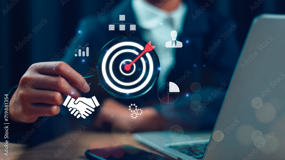 Businessman using magnifying glass focus to target icon which for ...