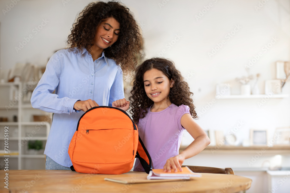 Young european mother and her preteen daughter preparing backpack for ...